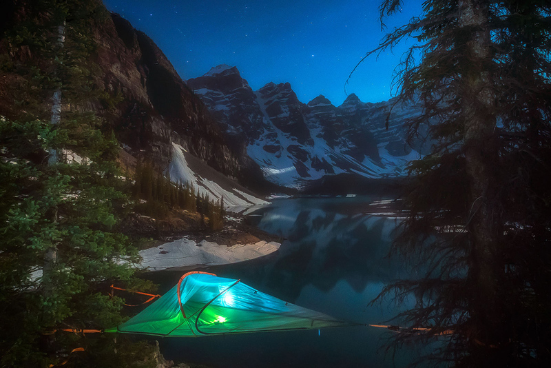 Tentsile tree tent suspended above the water surrounded by mountains ...